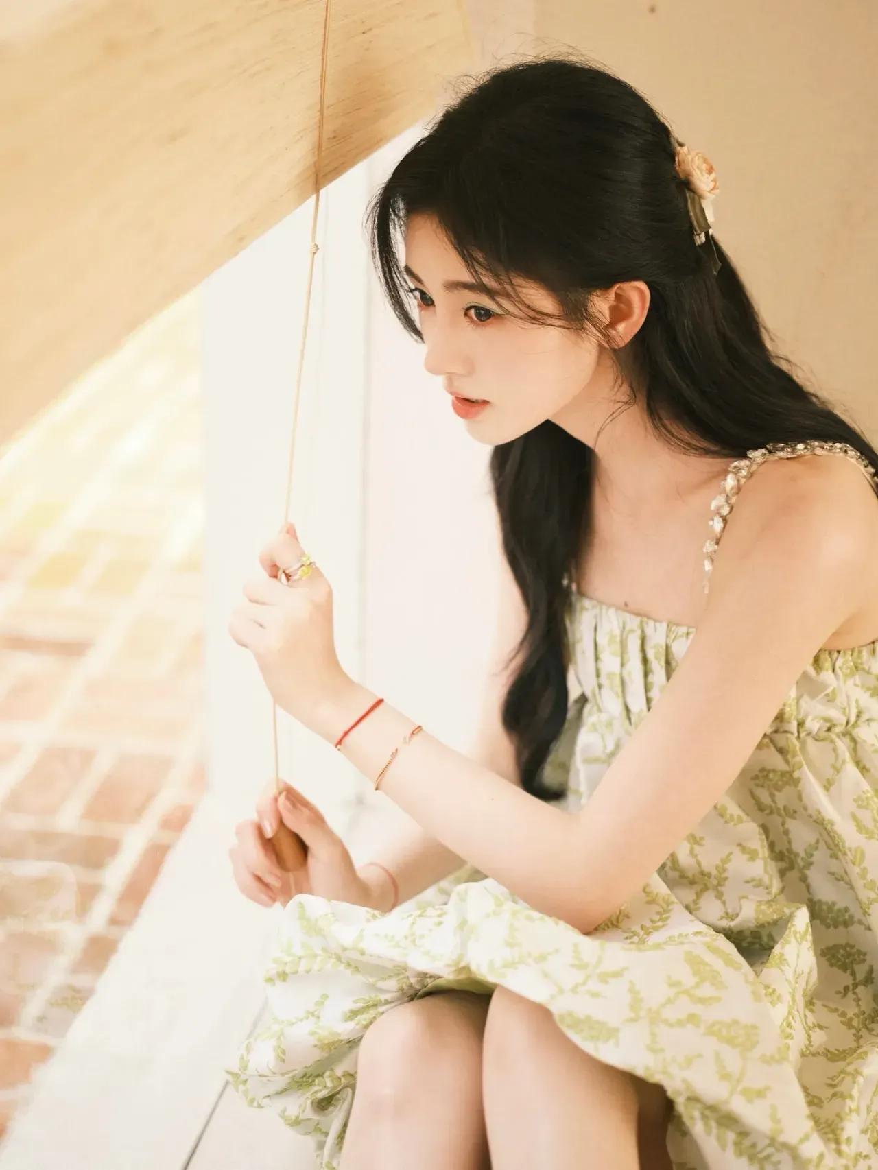 Ju Jingyi has long curly hair and a green floral suspender skirt. The ...