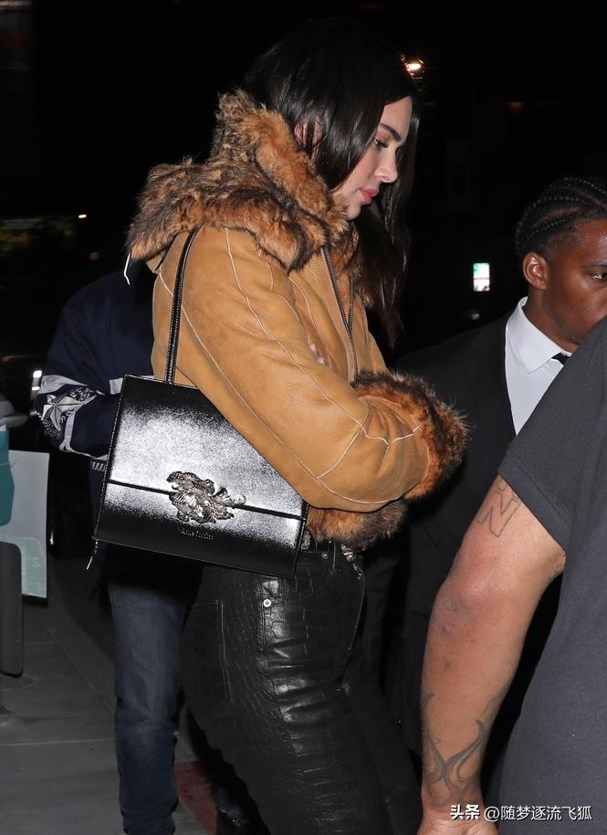 Kendall Jenner wears a brown jacket and black leather pants and walks ...