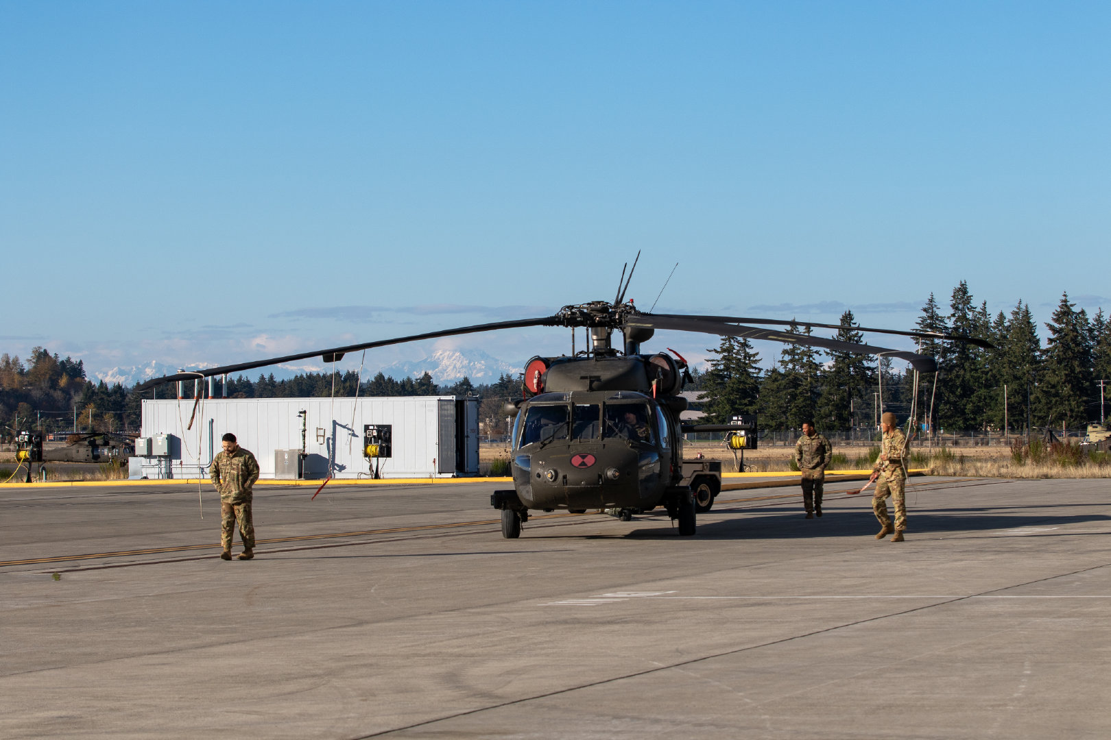 Soldiers of the 16th Combat Aviation Brigade maintain an AH-64E Apache ...
