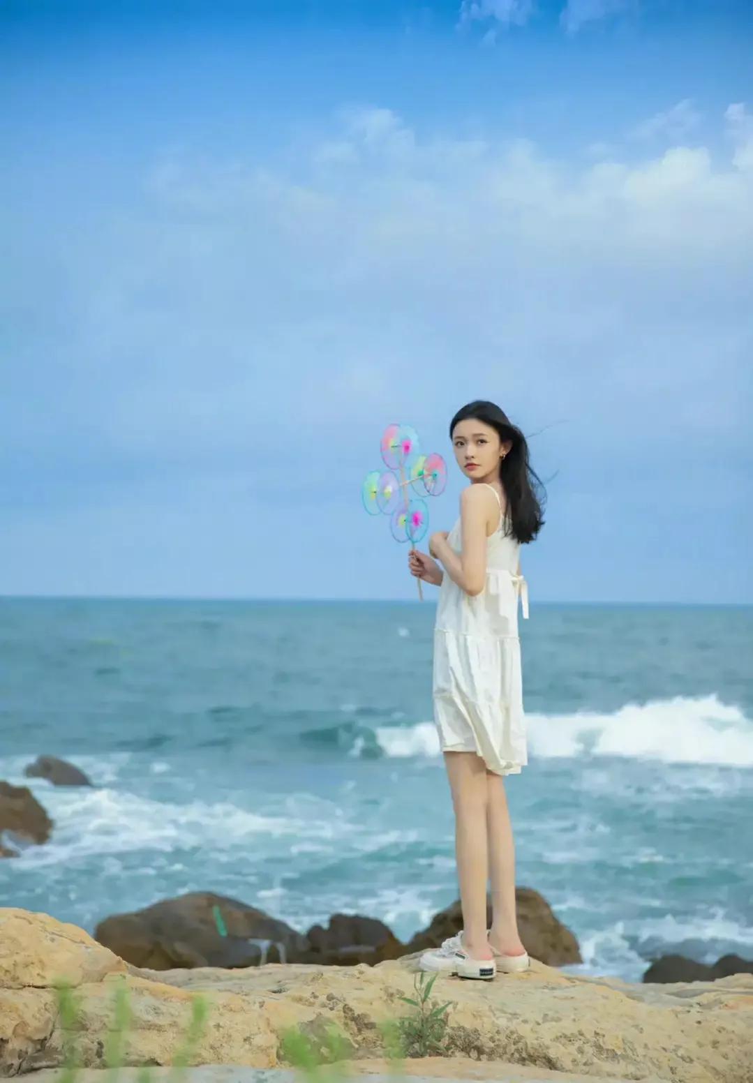Lin Yun's beach photo by the sea, wearing a white dress with suspenders ...