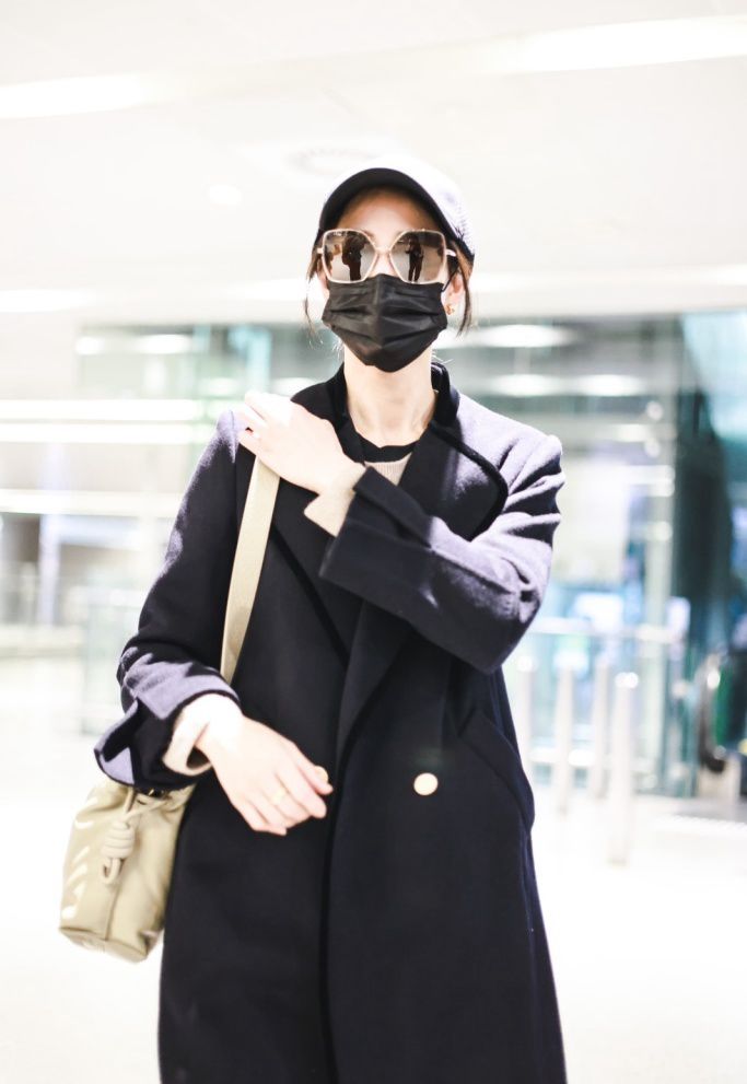 40-year-old Zhang Junning walks to the airport, wearing a black coat ...