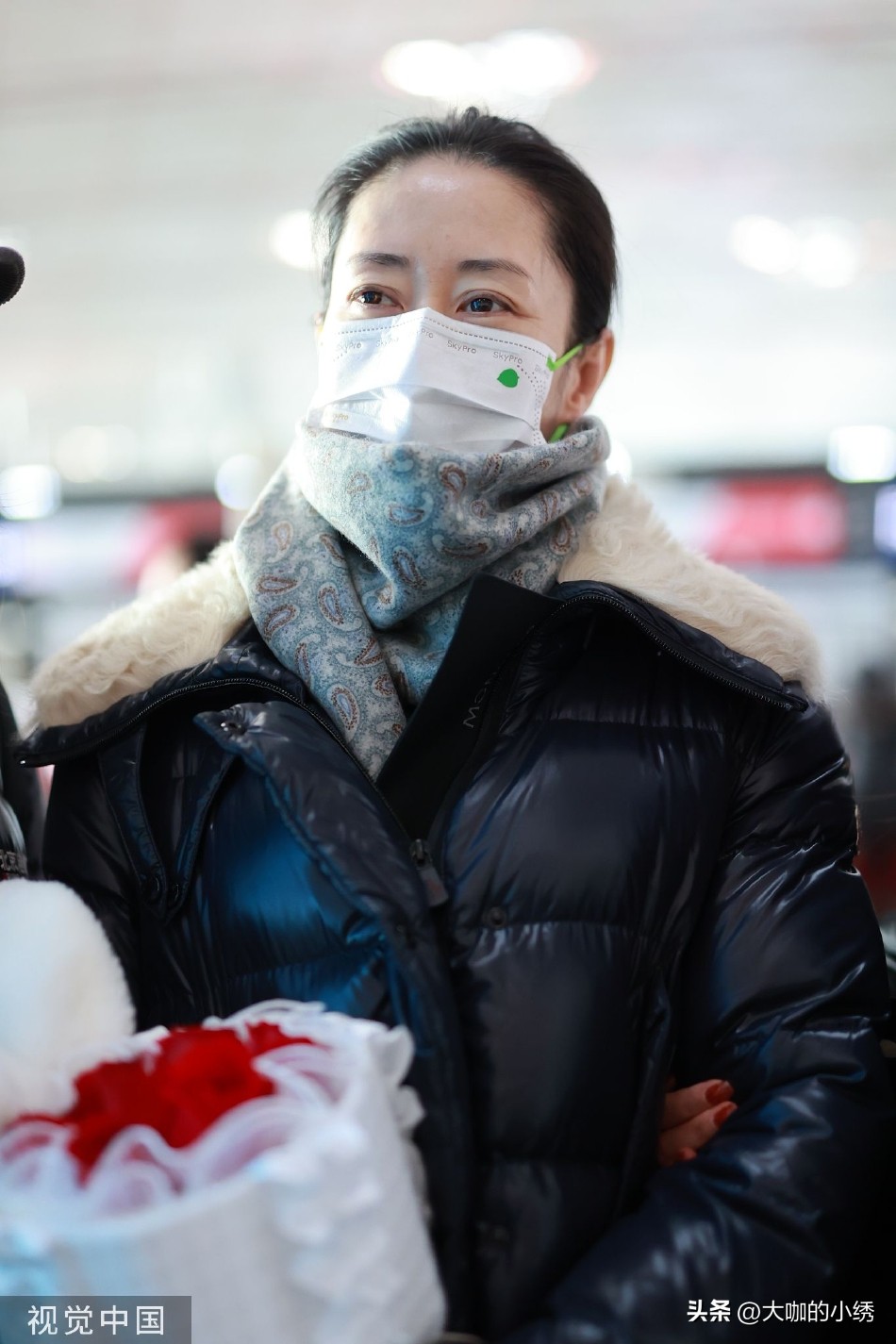 Liu Mintao appeared in a low-key black coat with lapel collar, holding ...