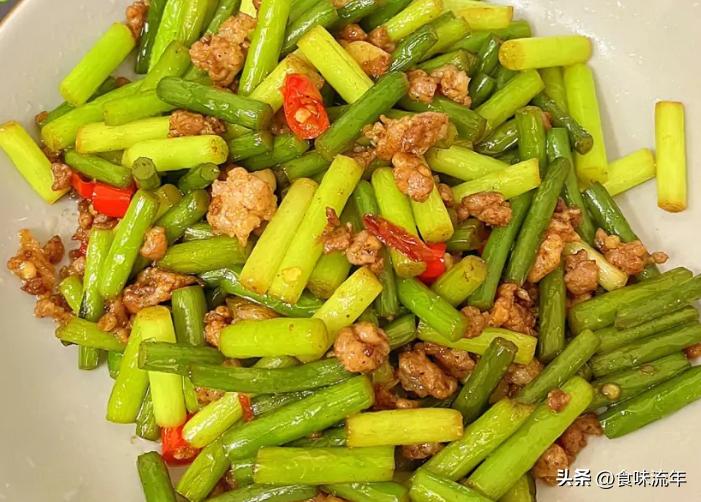 Stir-fried minced pork with garlic stalks that are burnt, tender and ...