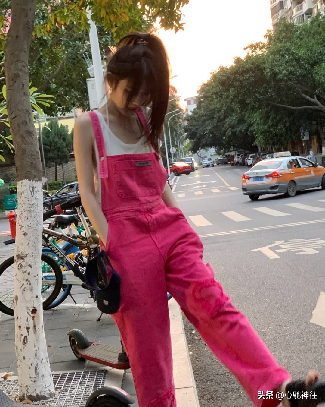 The rose red denim overalls are worn with a white round neck vest ...