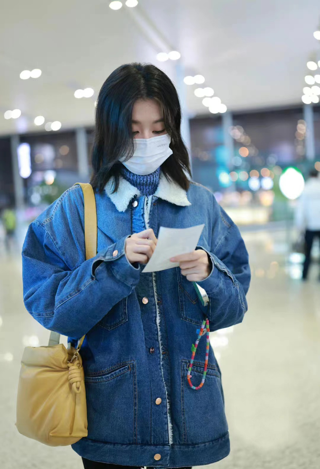 Qiao Xin walked to the airport, wearing a denim jacket with a flip ...