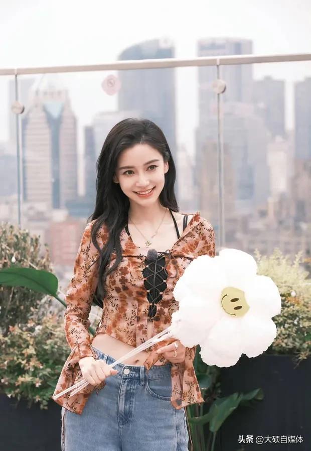 Angelababy holds a sunflower balloon in her hand, with a sweet smile ...