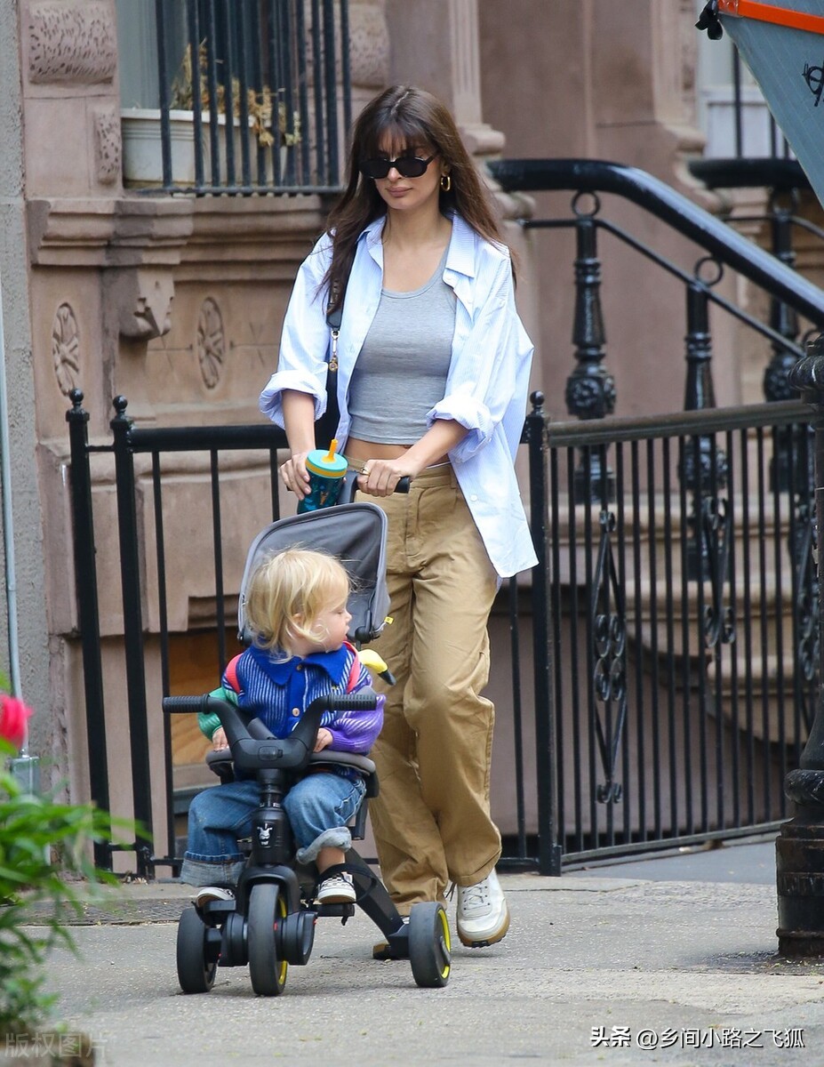 Emily Ratajkowski is wearing a white shirt + gray vest + khaki trousers ...