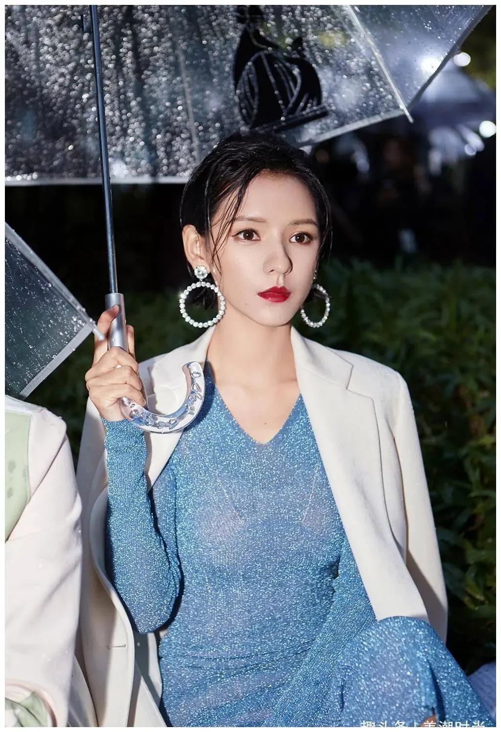 Zhang Yuxi is romantically watching the show in the rain, wearing a ...