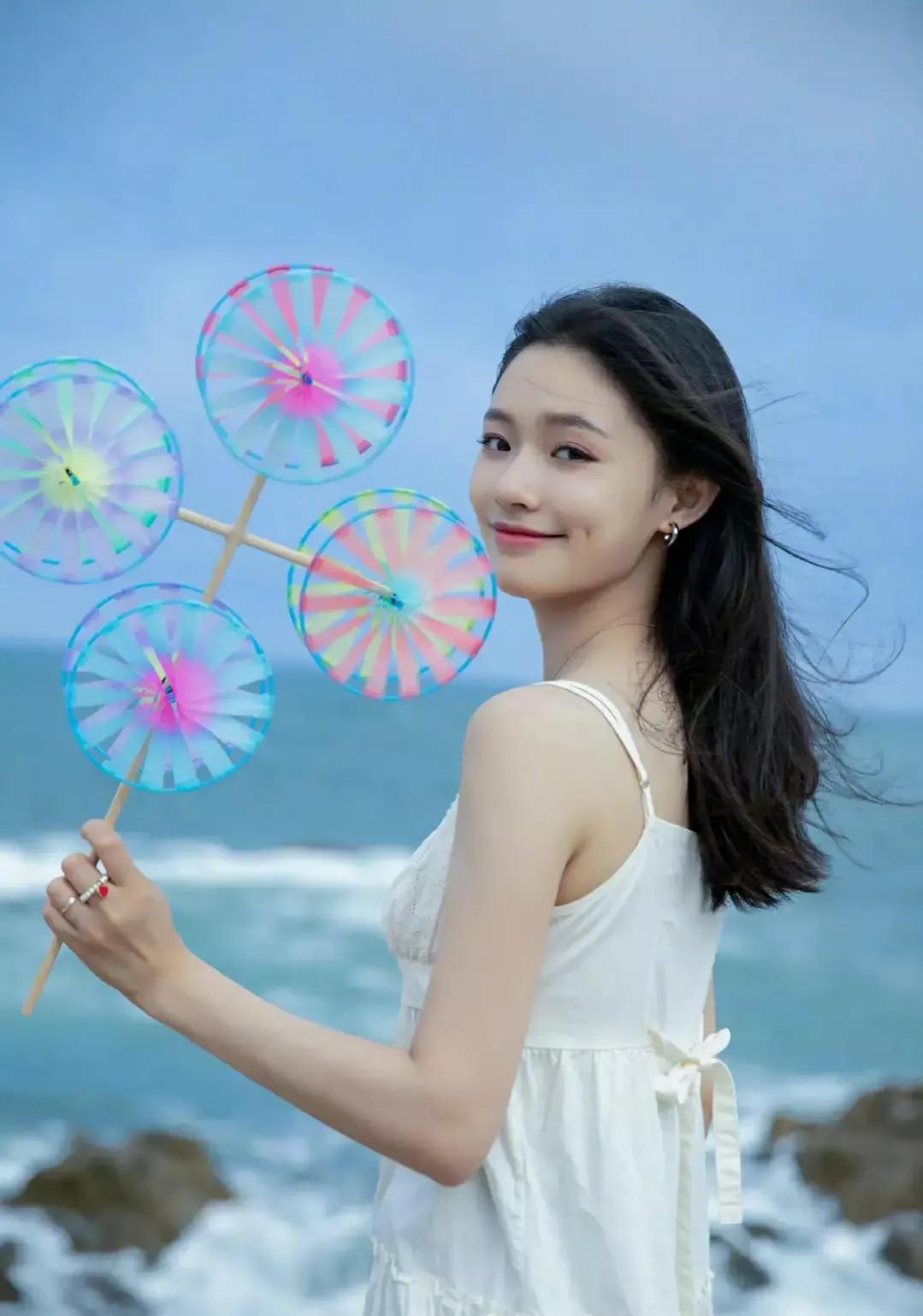 Lin Yun's beach photo by the sea, wearing a white dress with suspenders ...