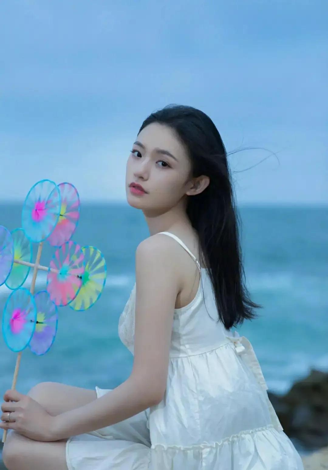 Lin Yun's beach photo by the sea, wearing a white dress with suspenders ...