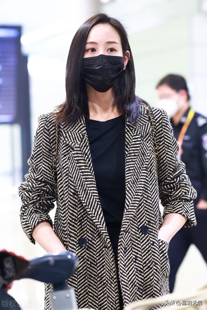 Zhang Junning arrived at Shanghai Airport, wearing a striped suit with ...
