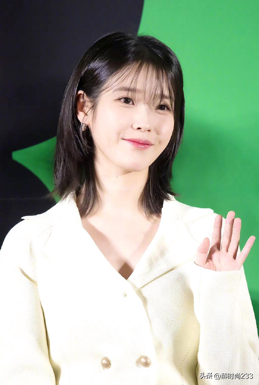 IU attended the press conference, dressed in a white suit with short ...