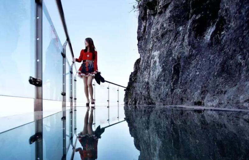 The beautiful woman wore a skirt to visit the glass plank road in ...